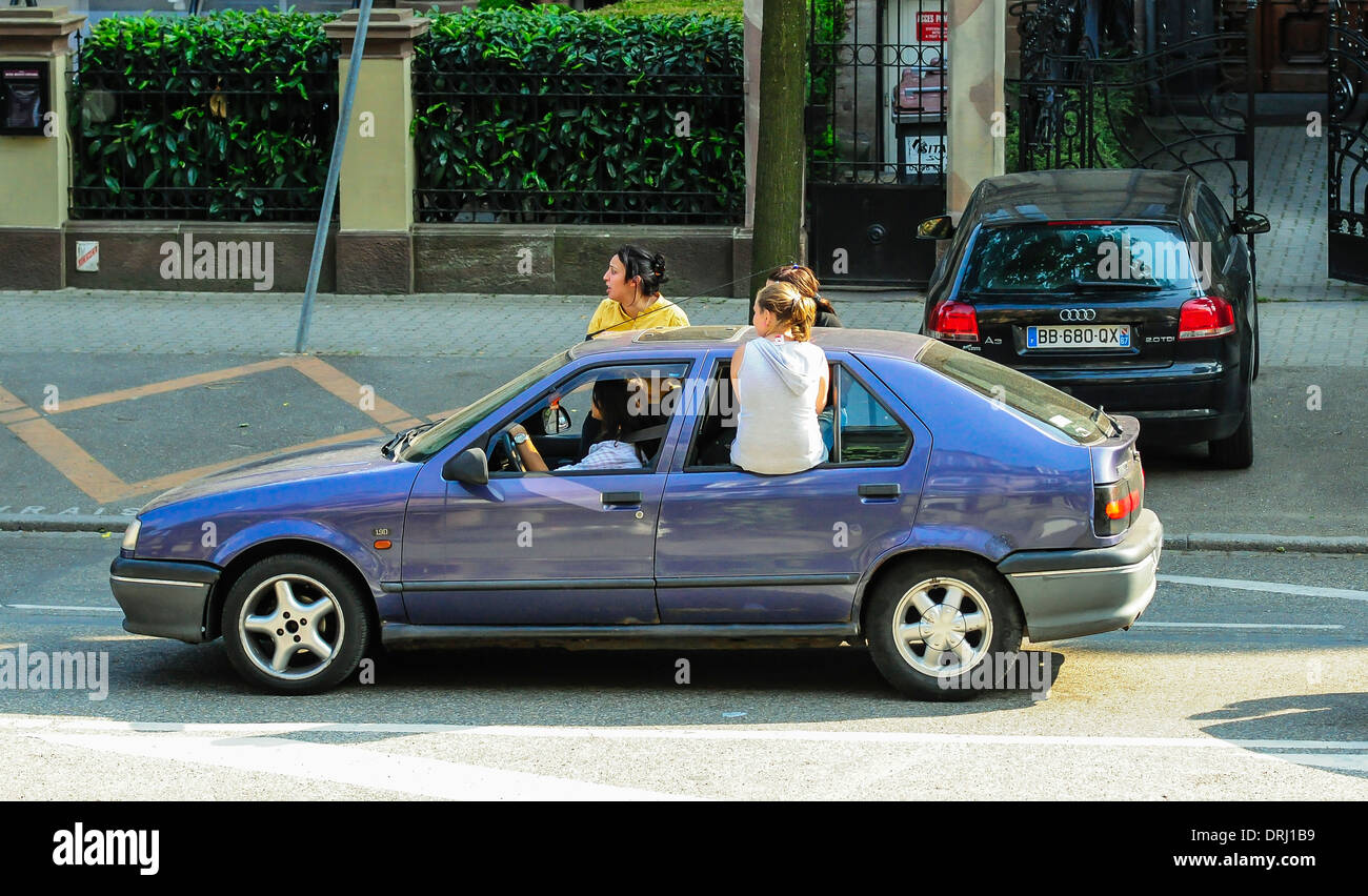 Young women sitting outside car while driving France Stock Photo - Alamy