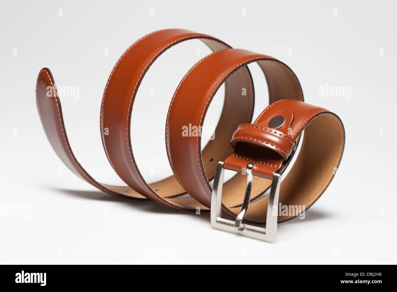 brown rolled-up leather belt isolated on white background Stock Photo ...