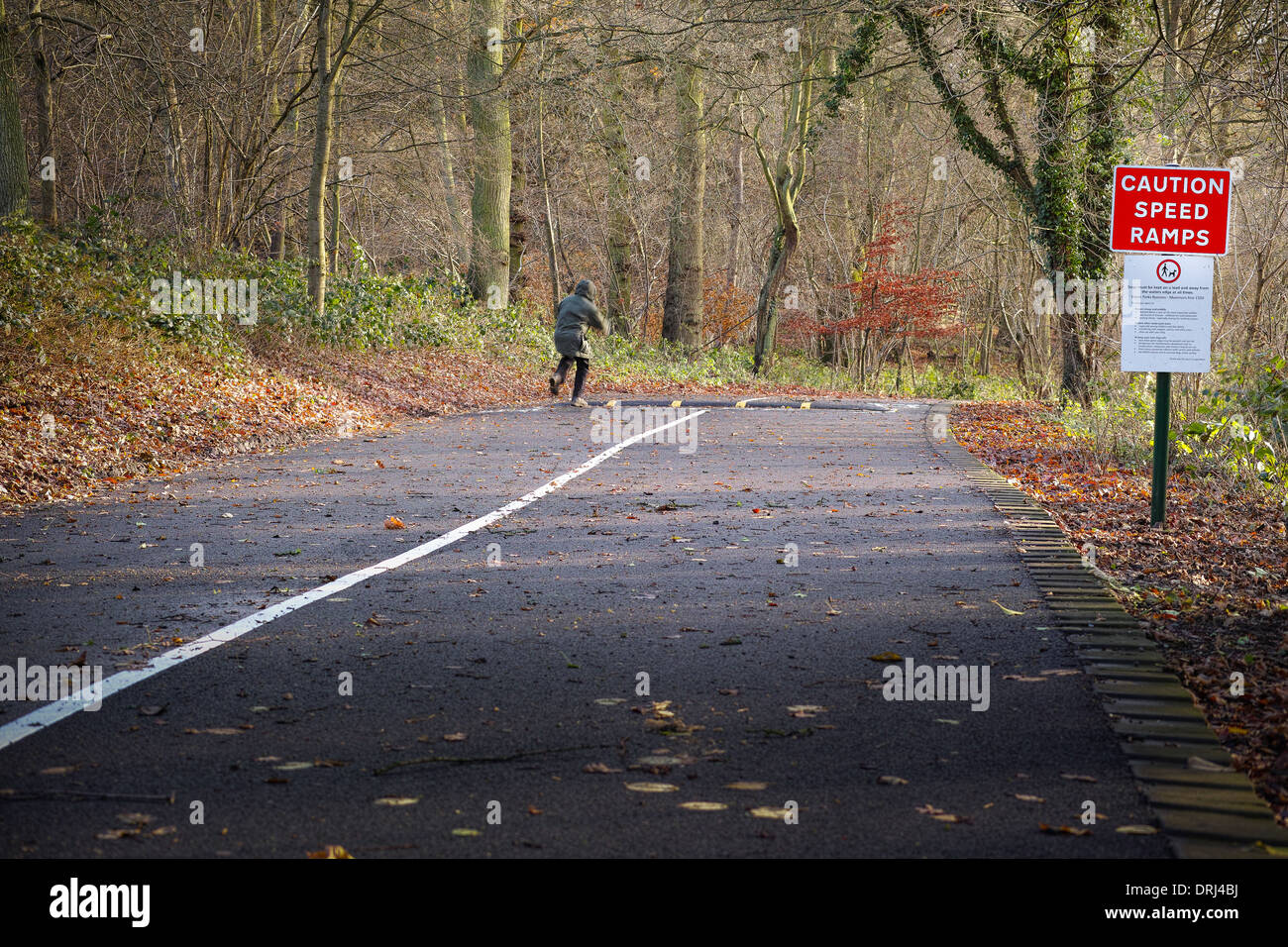 Man jumping over a speed ramp on a tarmac road in the countryside Stock ...