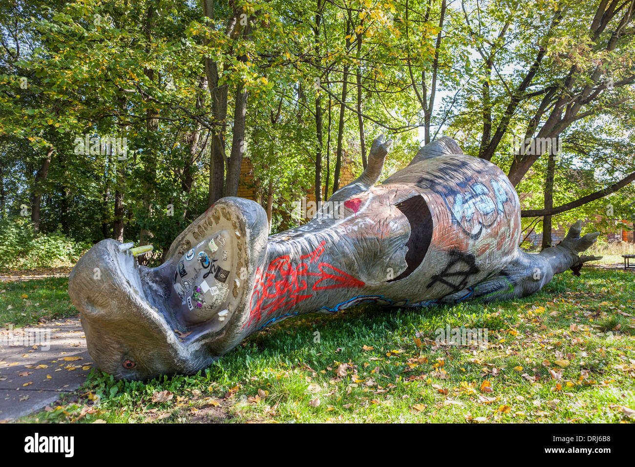 Damaged and broken dinosaur is covered in graffiti at the abandoned ...