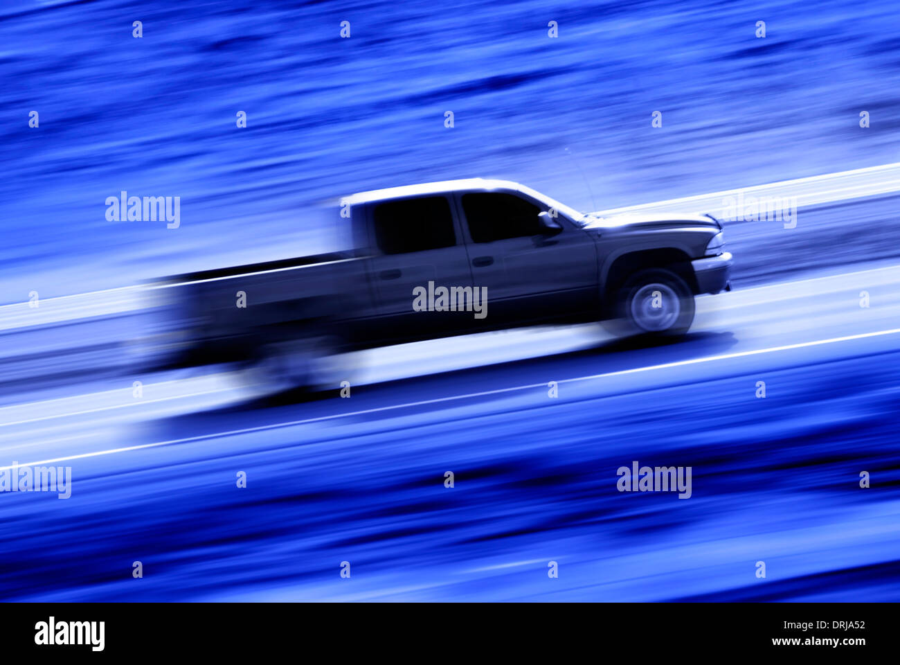 Speedy truck driving along road with blurred background Stock Photo - Alamy
