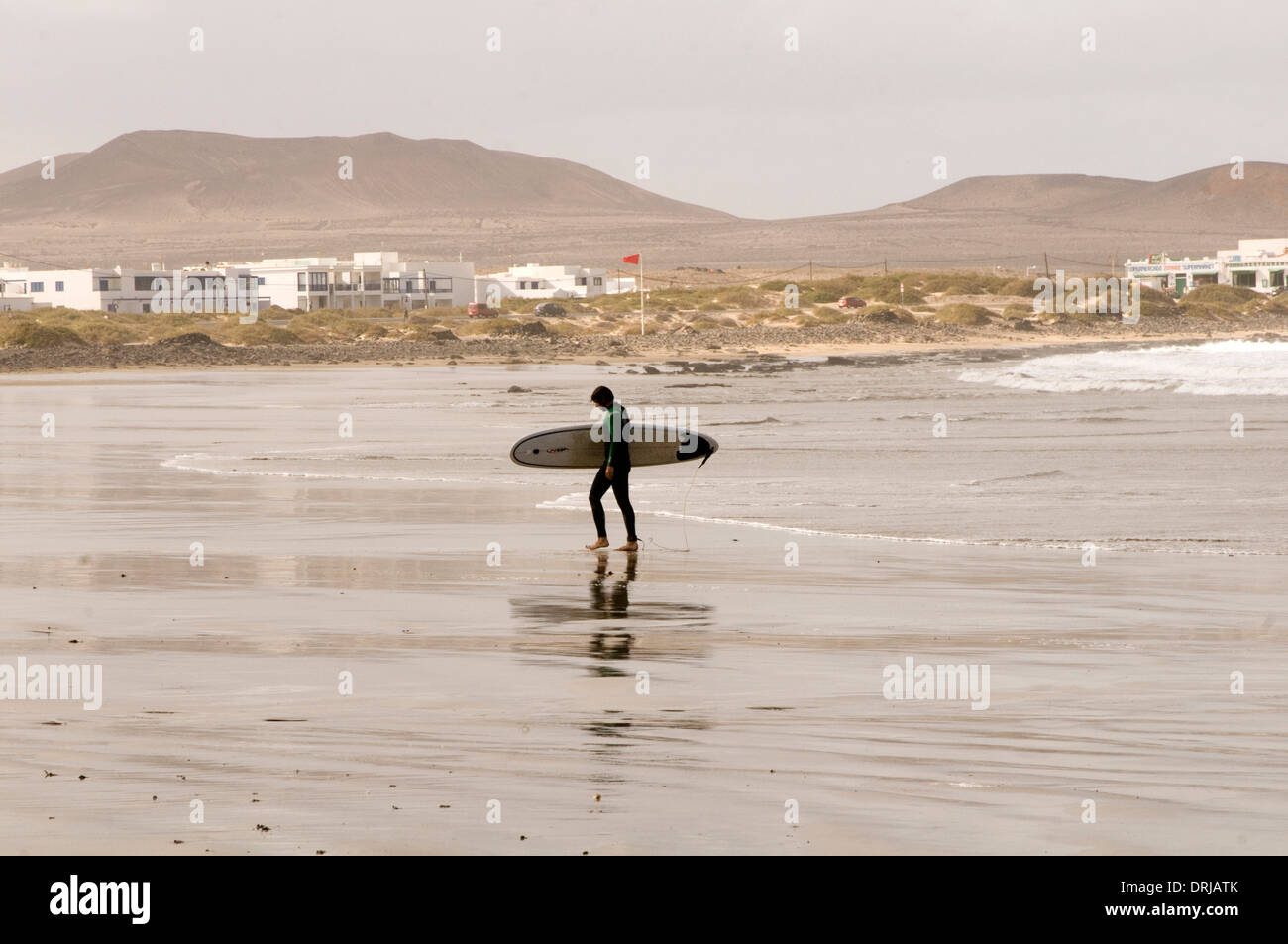 surfer walking out of the sea waves carrying his surfboard surf boards ...