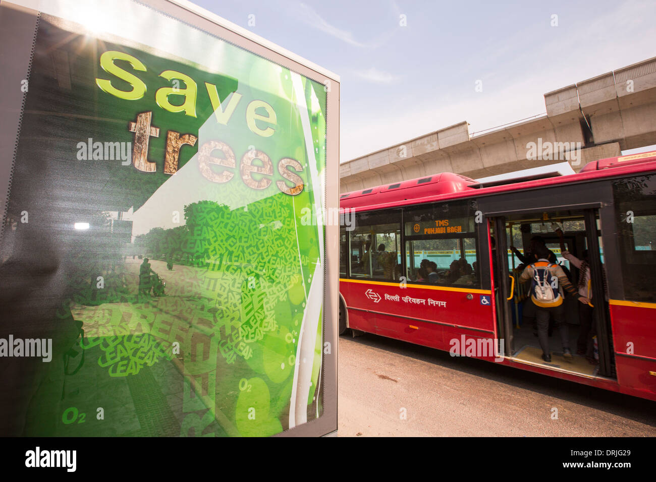 A save trees poster on a Delhi bus stop with tconstruction work on the ...