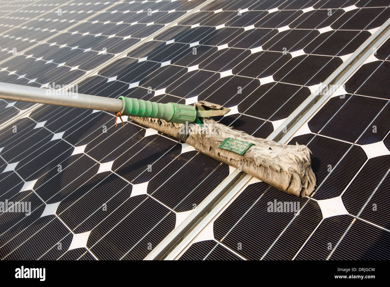 Workers washing the dust off solar panels at a 1 MW solar power station ...