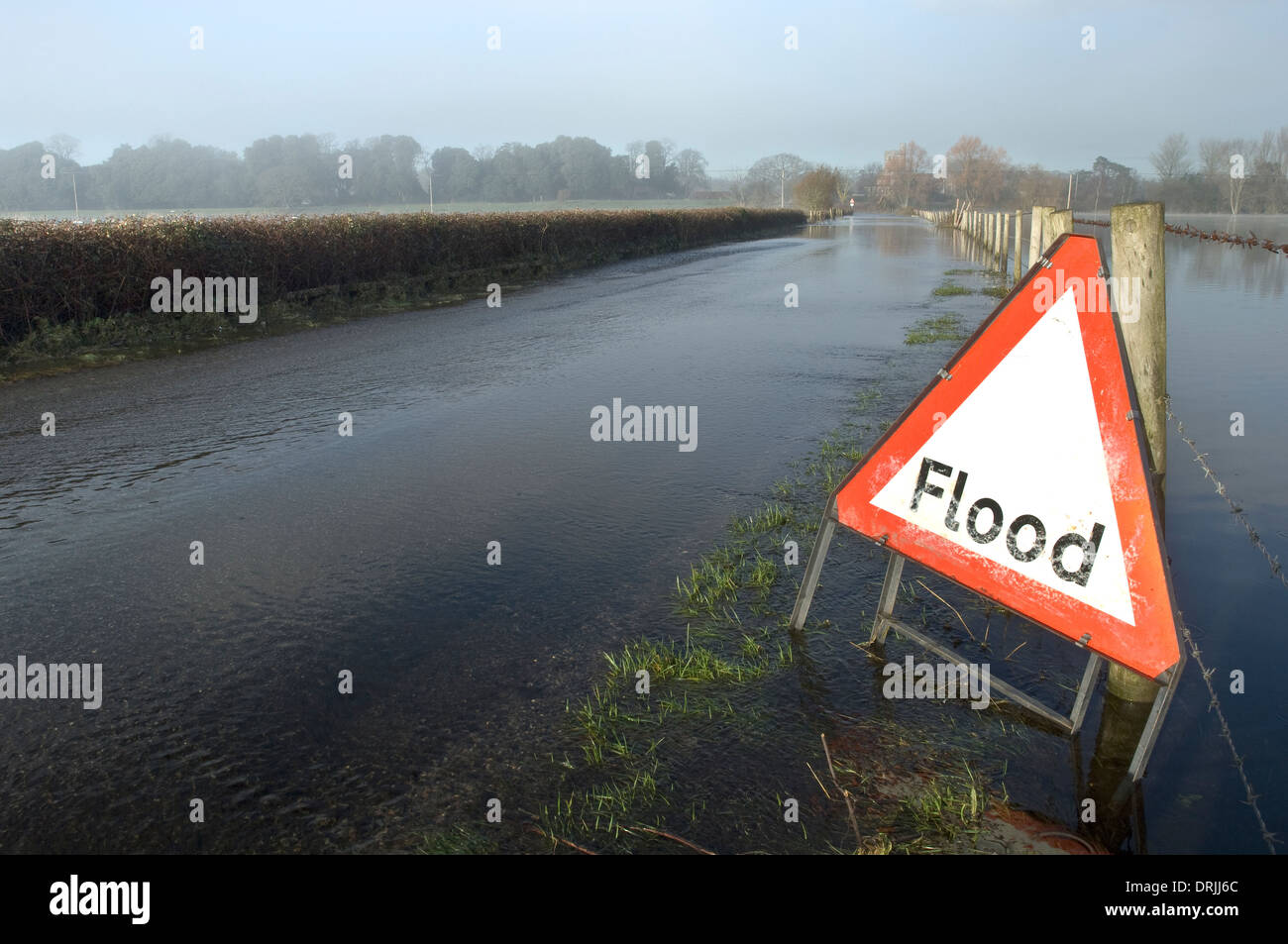 Flooded country road with warning sign Stock Photo - Alamy