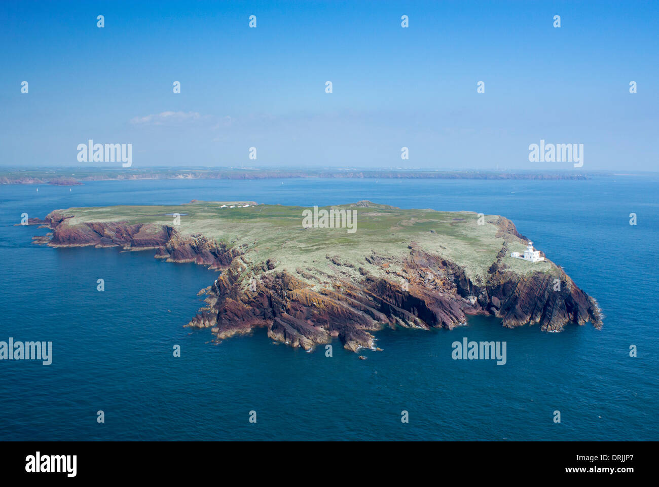 Aerial view of Skokholm island and lighthouse looking back to mainland ...