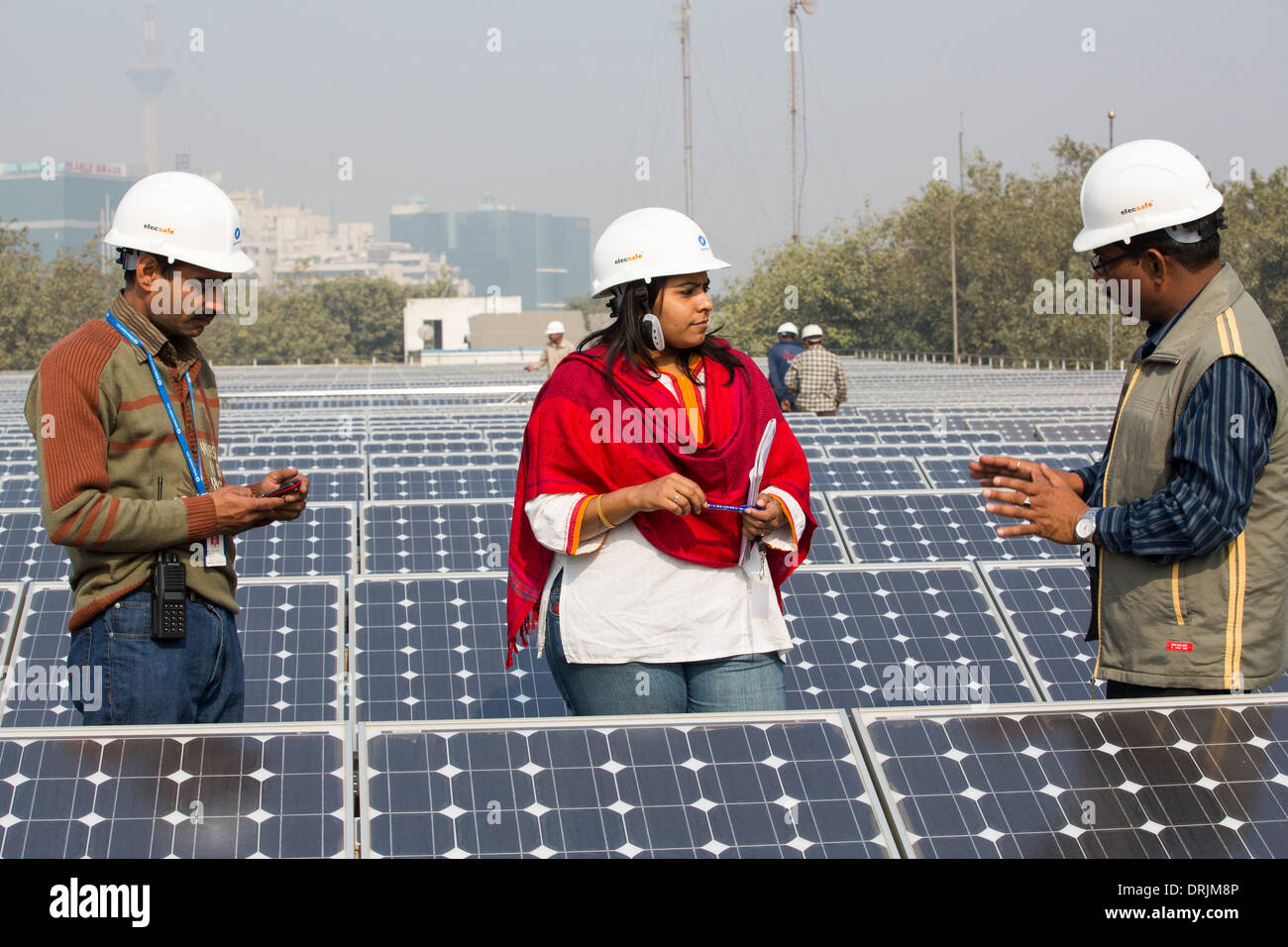 Workers at a 1 MW solar power station run by Tata power on the roof of ...