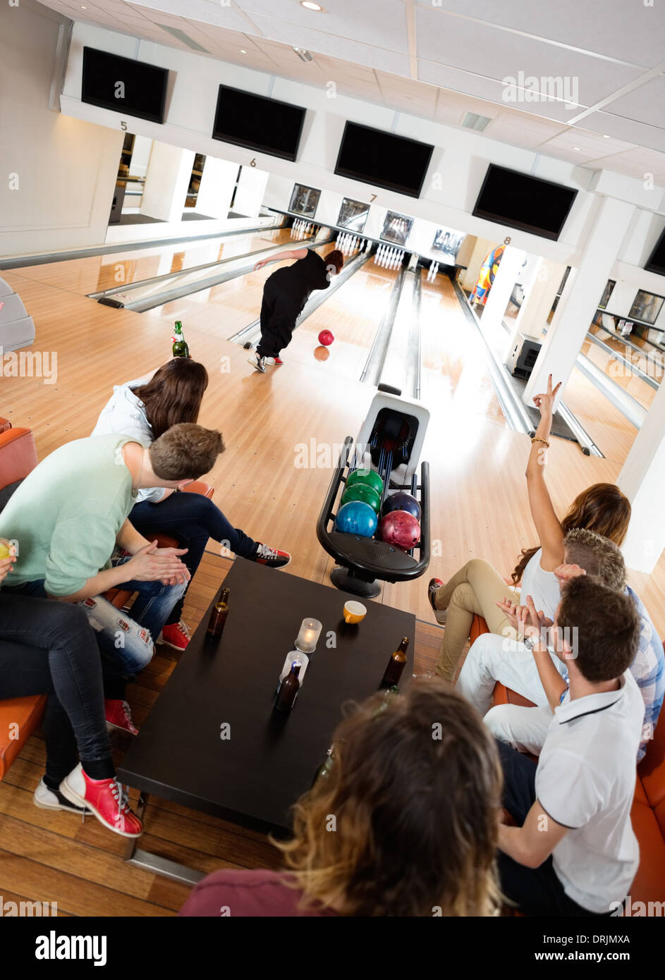Friends Cheering Woman Bowling in Club Stock Photo - Alamy
