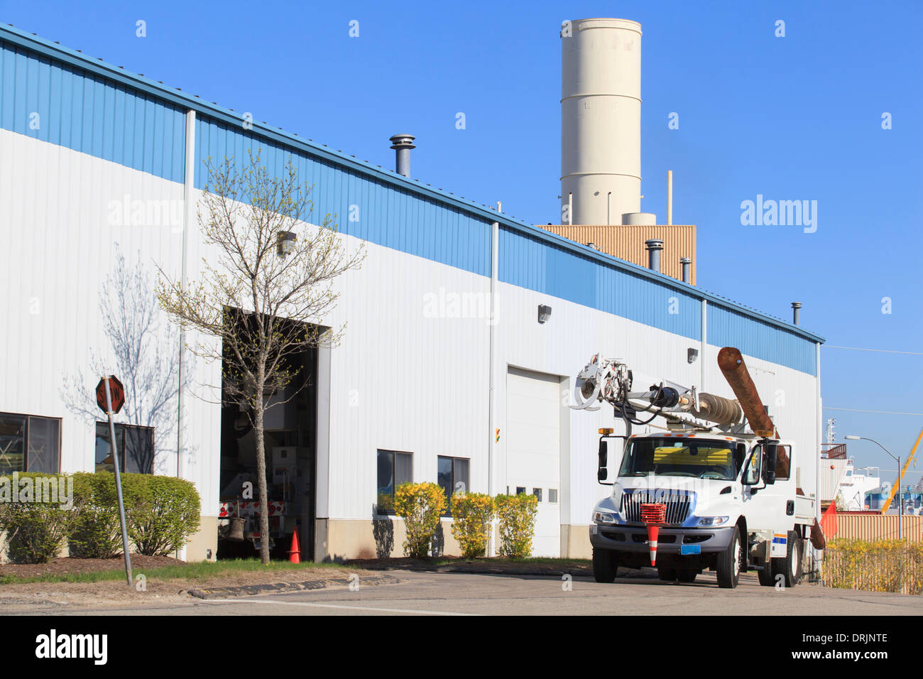 Utility truck with hydraulic drill for installing new power pole beside ...