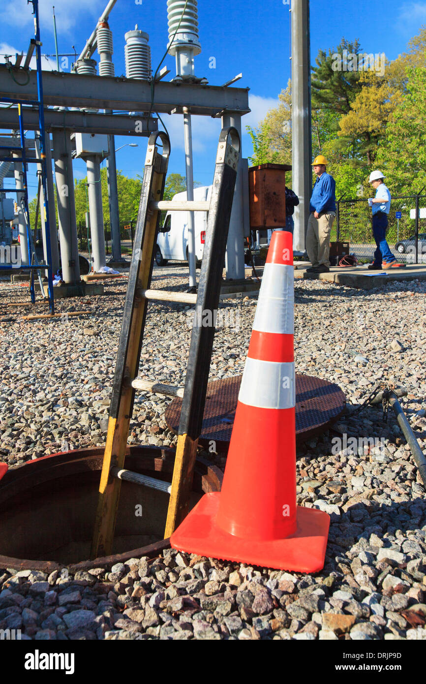 Ladder in manhole and warning cones at high voltage power distribution ...