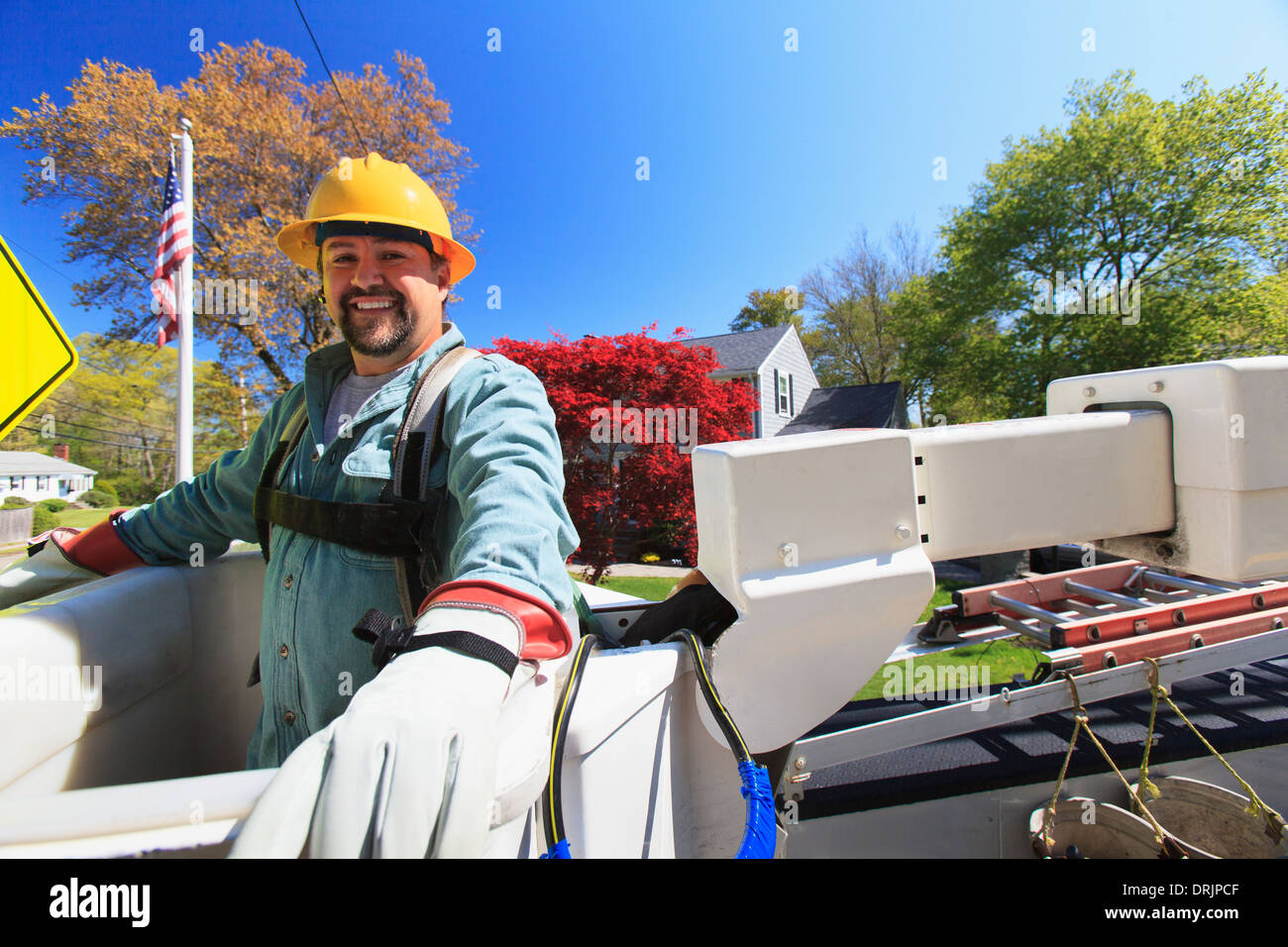 Power engineer in lift bucket with safety equipment for power lines at ...