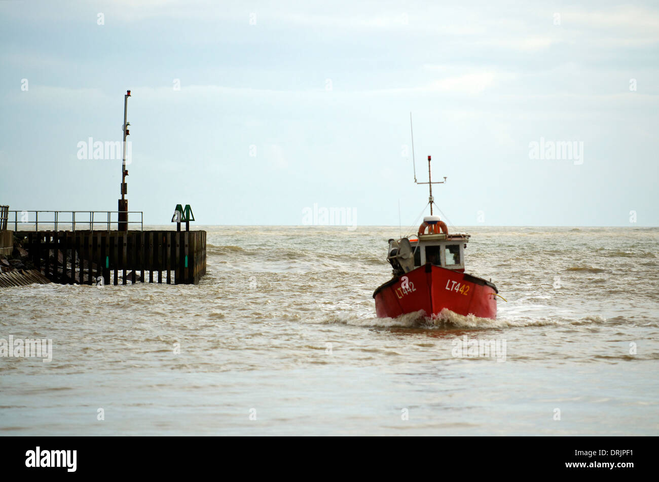 A small inshore fishing boat coming back into port at Walberswick ...