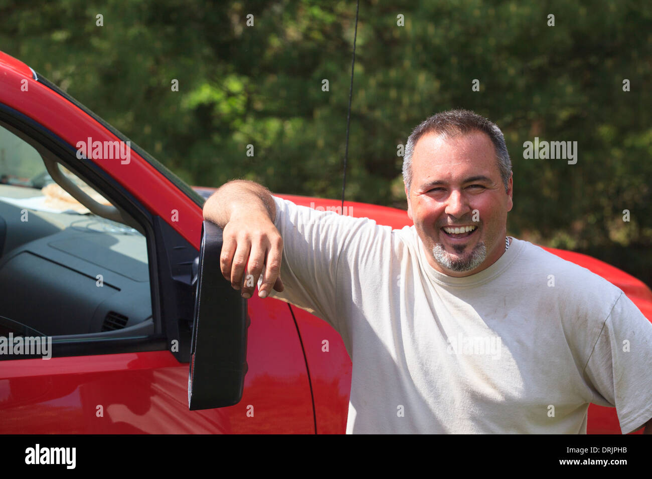 Landscaper smiling next to his truck Stock Photo - Alamy