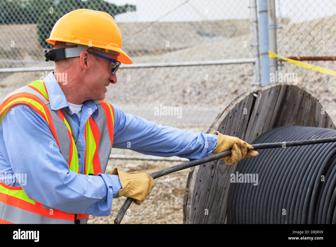 Electrical engineer pulling power cable from reel Stock Photo - Alamy