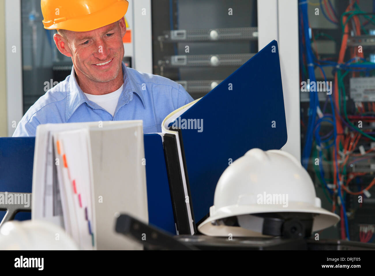 Electrical engineer reviewing data logs in broadband communication hub ...