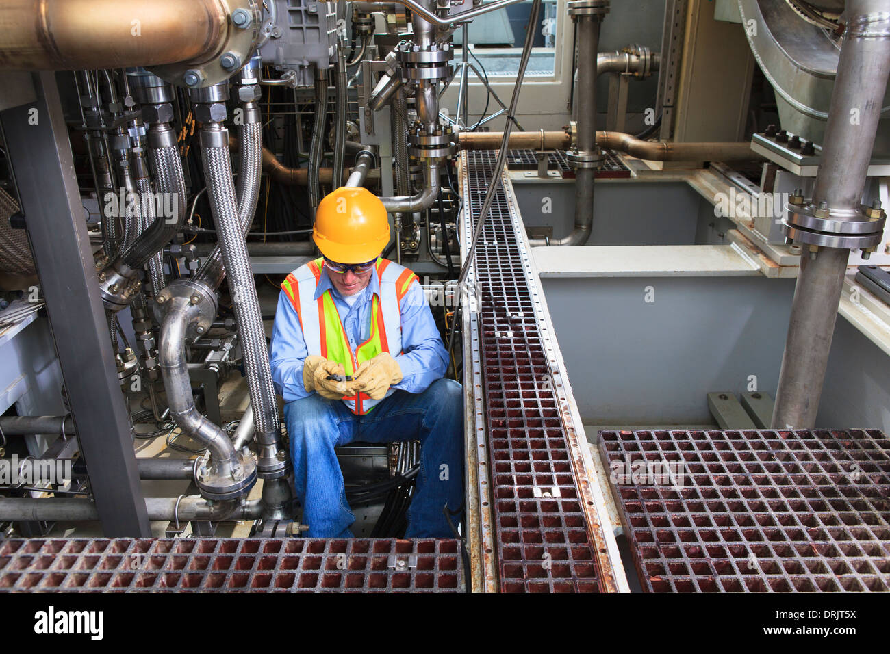 Engineer working on gas turbine which drives generators in power plant ...