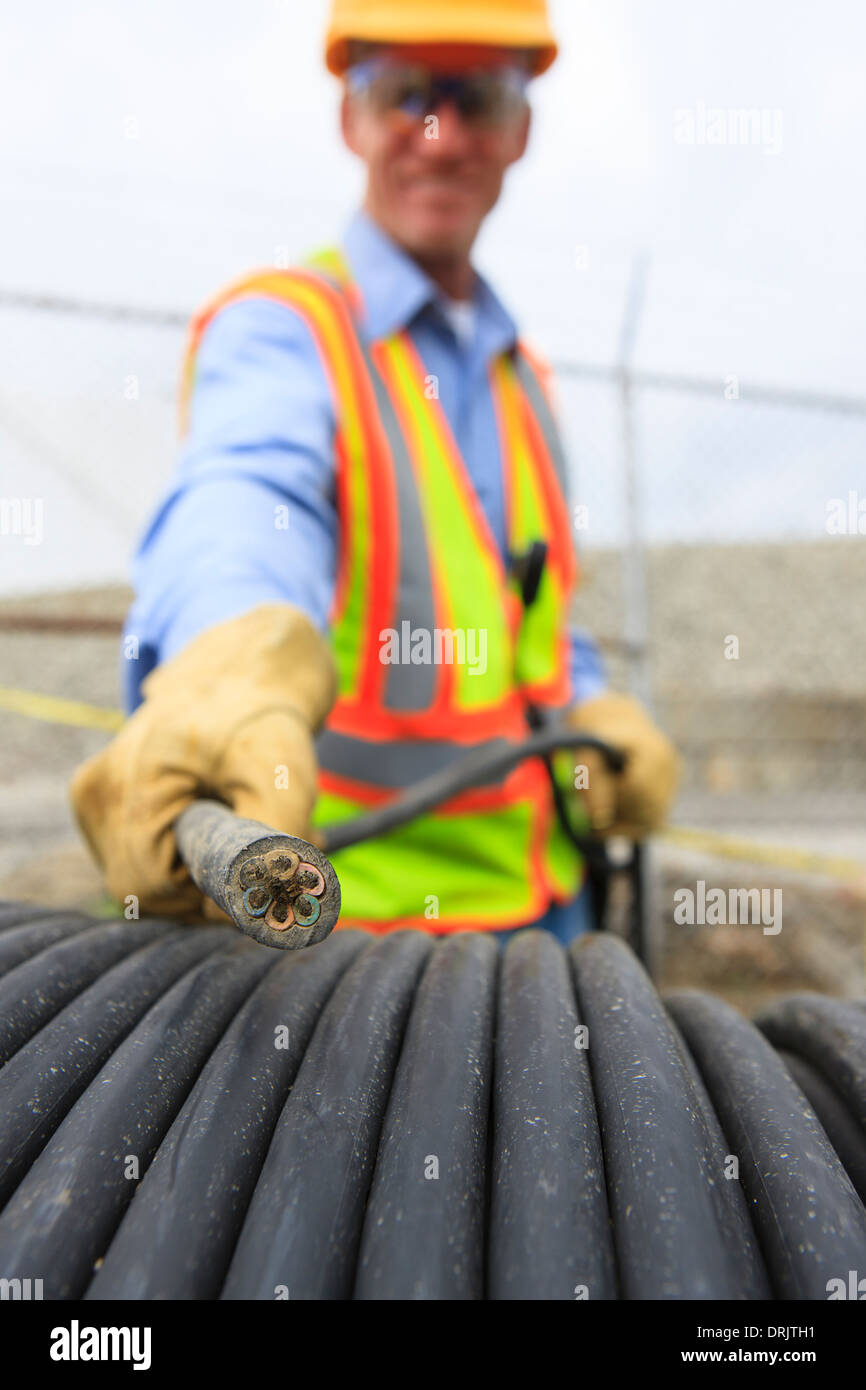 Engineer at electric power plant examining electrical distribution wire ...