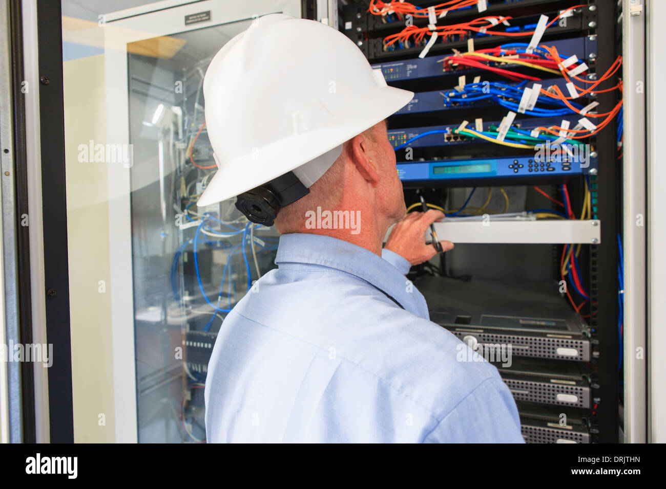 Engineer at electric power plant control room looking at servers and ...