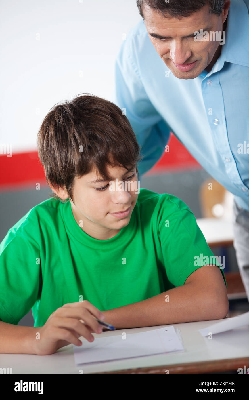 Mature Professor Assisting Teenage Boy At Desk Stock Photo - Alamy