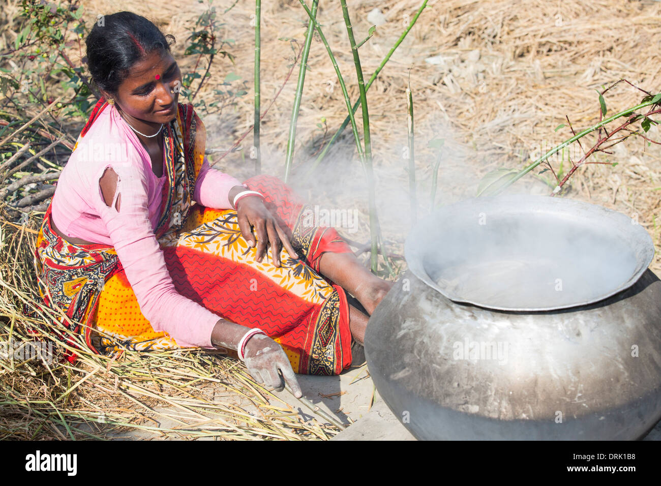 A woman boiling water on a traditional clay oven in the Sunderbans ...