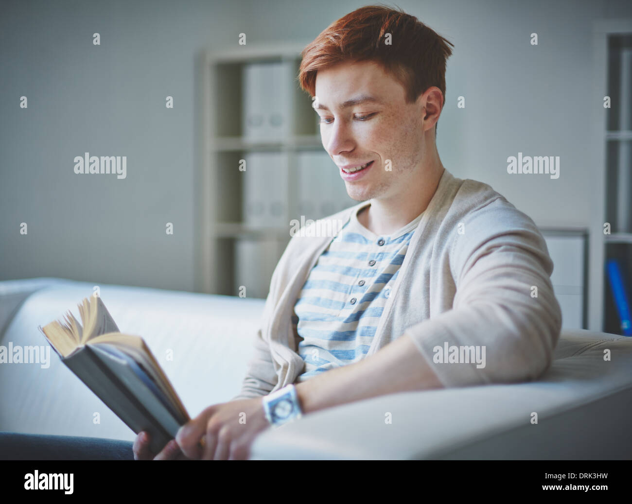 Portrait of young guy in casual clothes reading book Stock Photo - Alamy