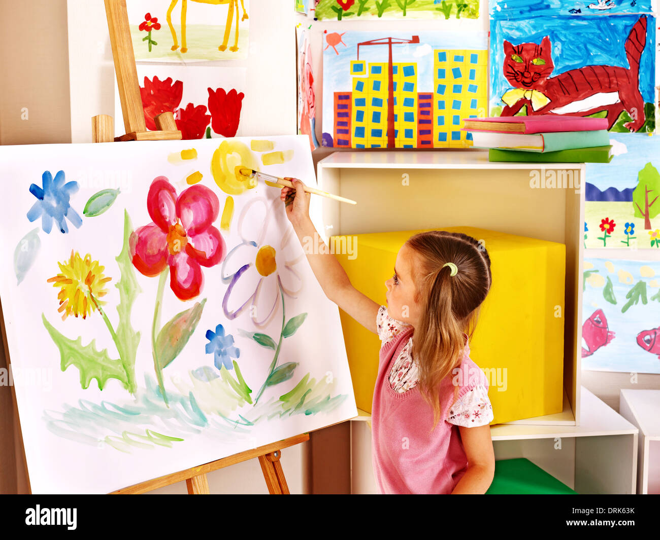 Child painting at easel in art class Stock Photo - Alamy
