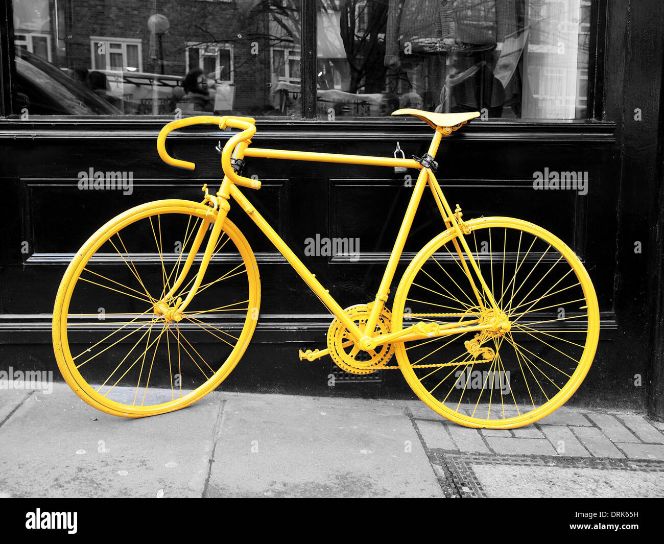 b&w photo of old yellow bike on the window of the coffe shop Stock ...