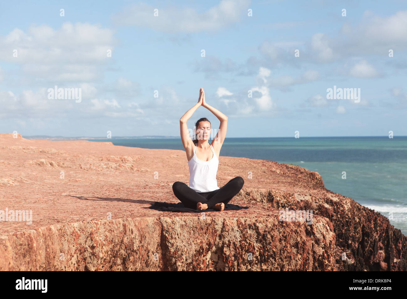 Yoga exercise sitting cross-legged on a cliff Stock Photo - Alamy