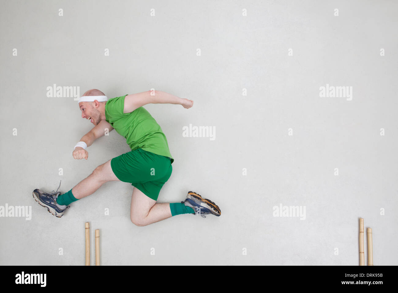 Man jumping over hurdle Stock Photo - Alamy