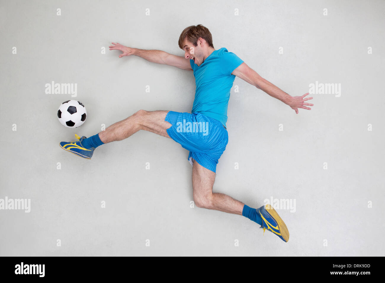 Man kicking football Stock Photo - Alamy