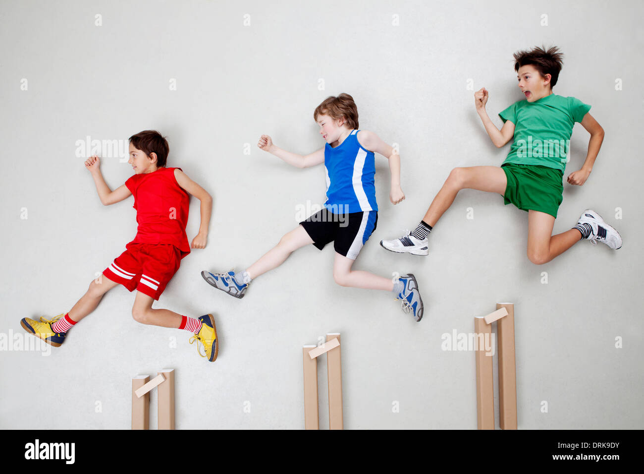 Boys jumping over hurdles Stock Photo - Alamy