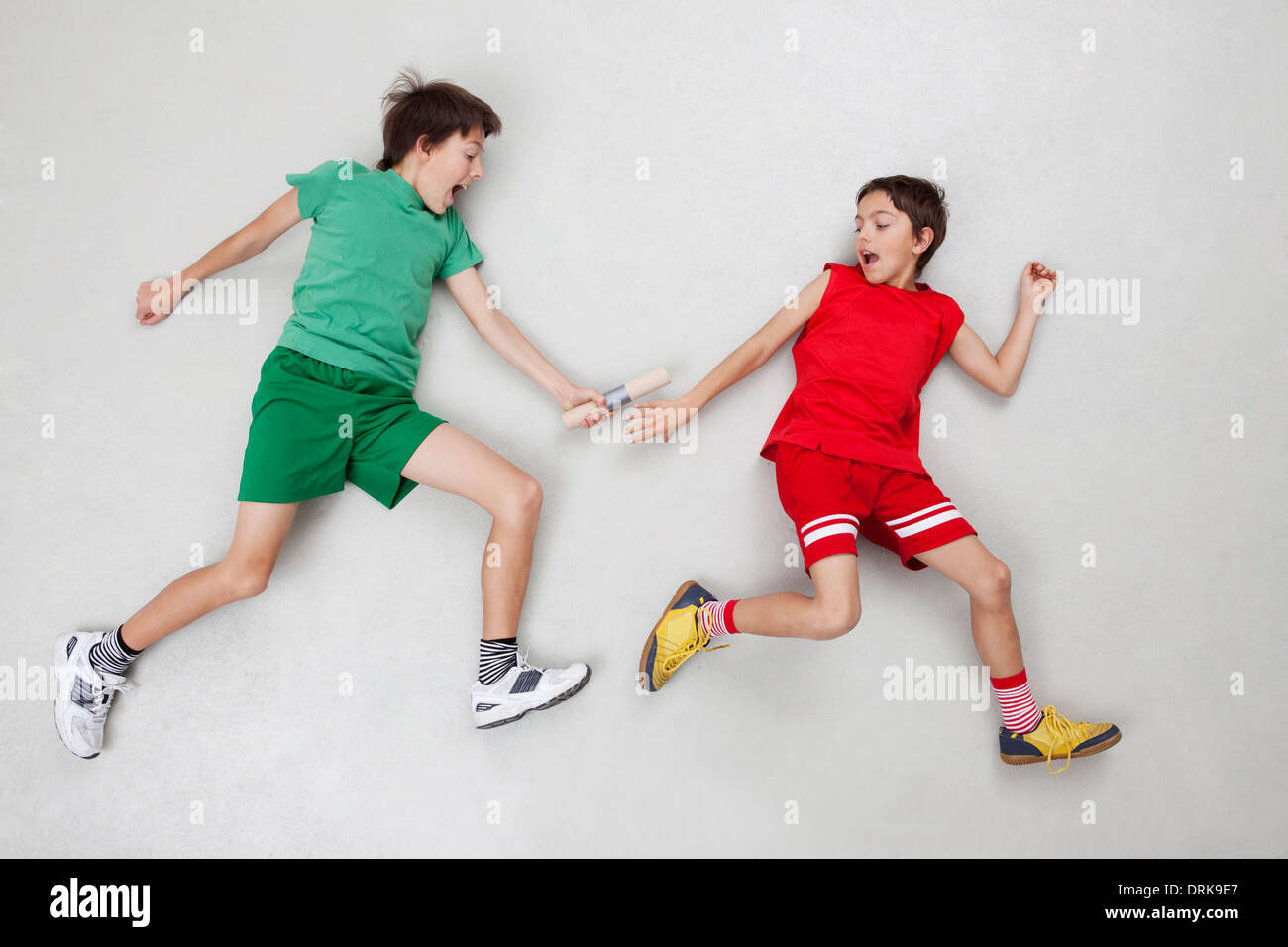Two boys handing over baton at relay race Stock Photo - Alamy
