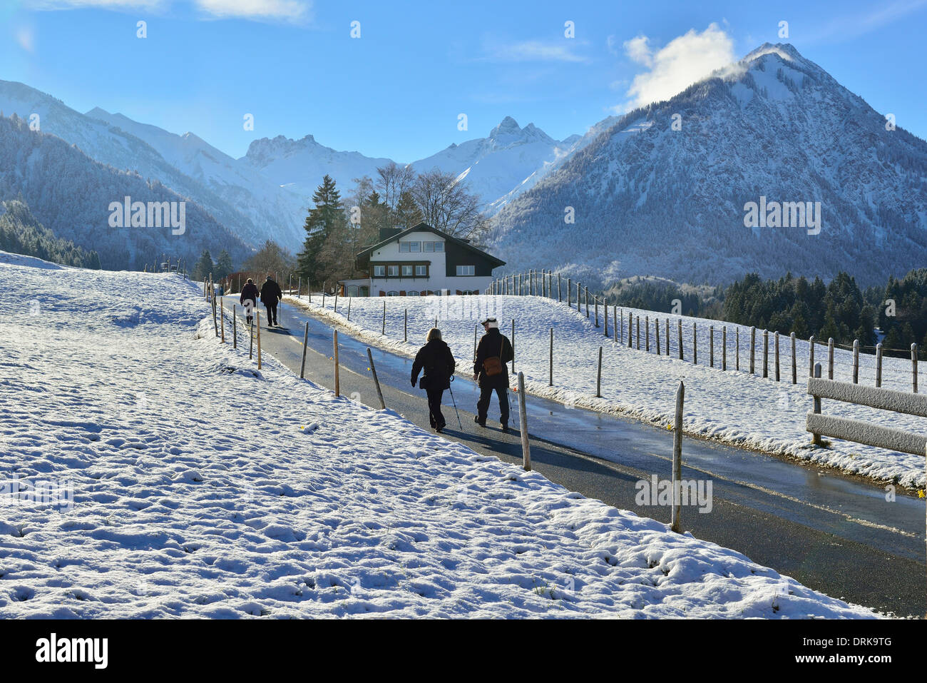 Walkers out on a brisk winter's walk in snow on trails above Oberstdorf ...