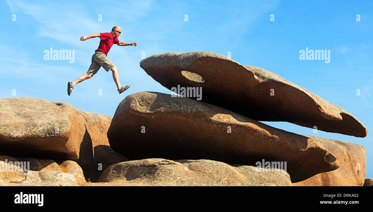 Mature man jumping on rocks hi-res stock photography and images - Alamy