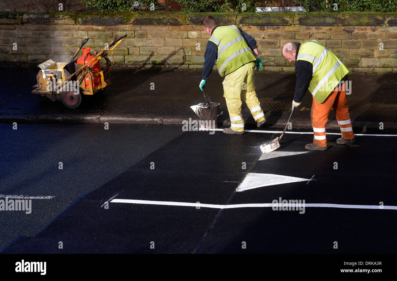 two workmen marking out lines after speed humps have been made Stock ...