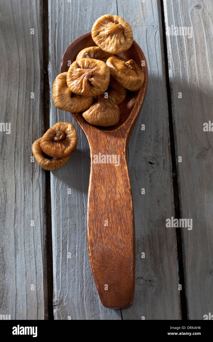 Wooden spoon with dried figs on wooden table Stock Photo - Alamy