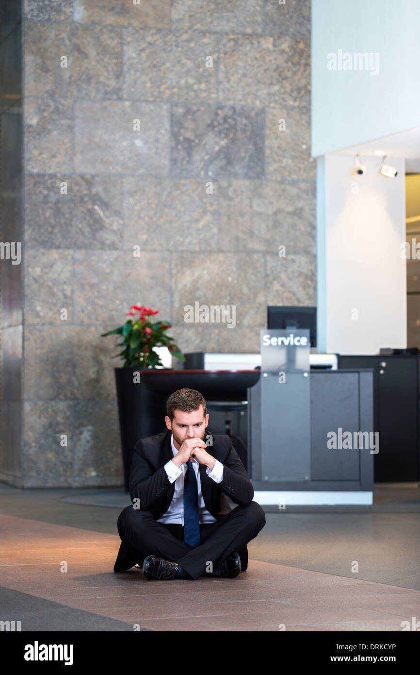 Germany, Businessman sitting cross-legged on floor Stock Photo - Alamy