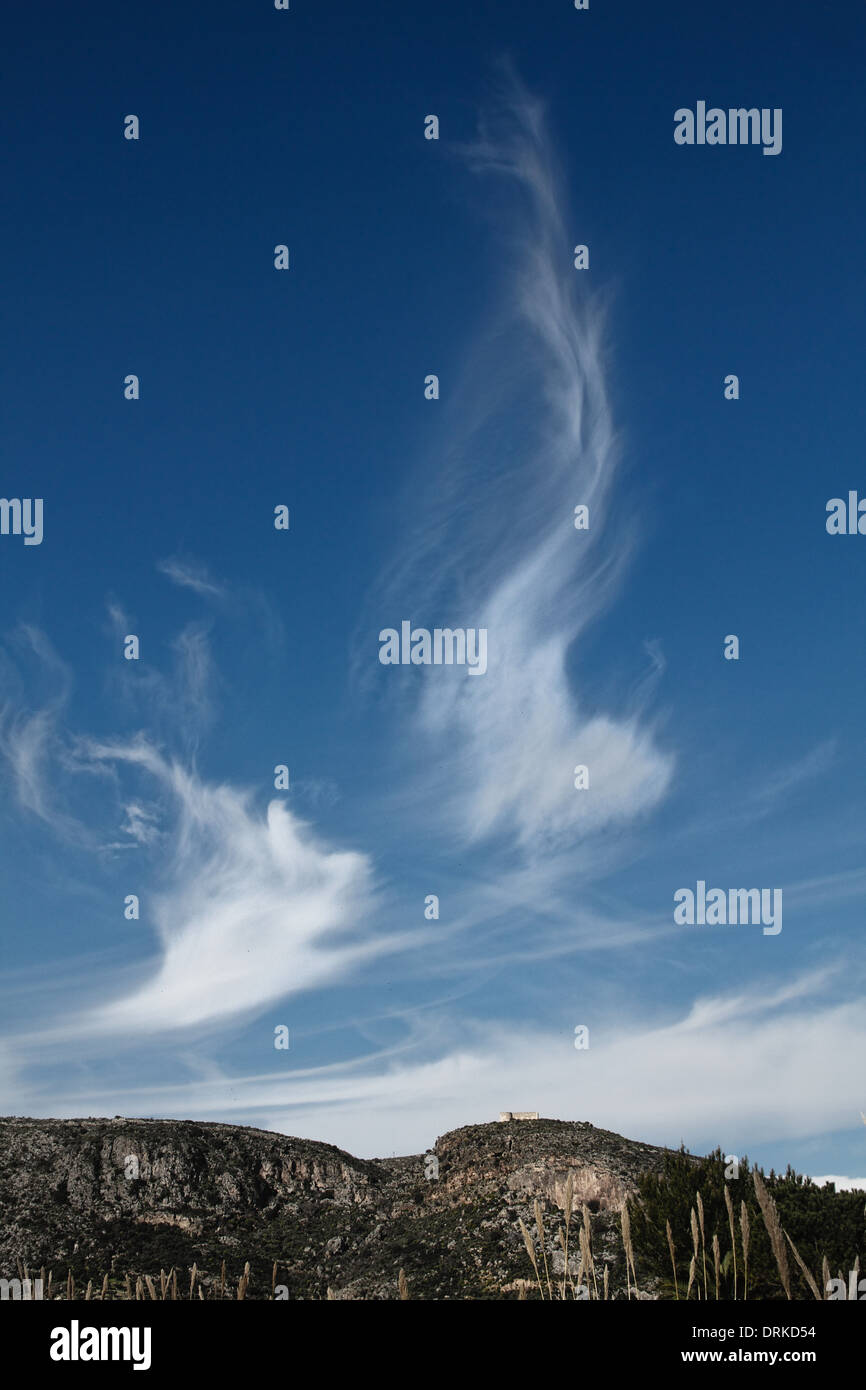 Curved filaments of Cirrus uncinus clouds form high in the sky above ...