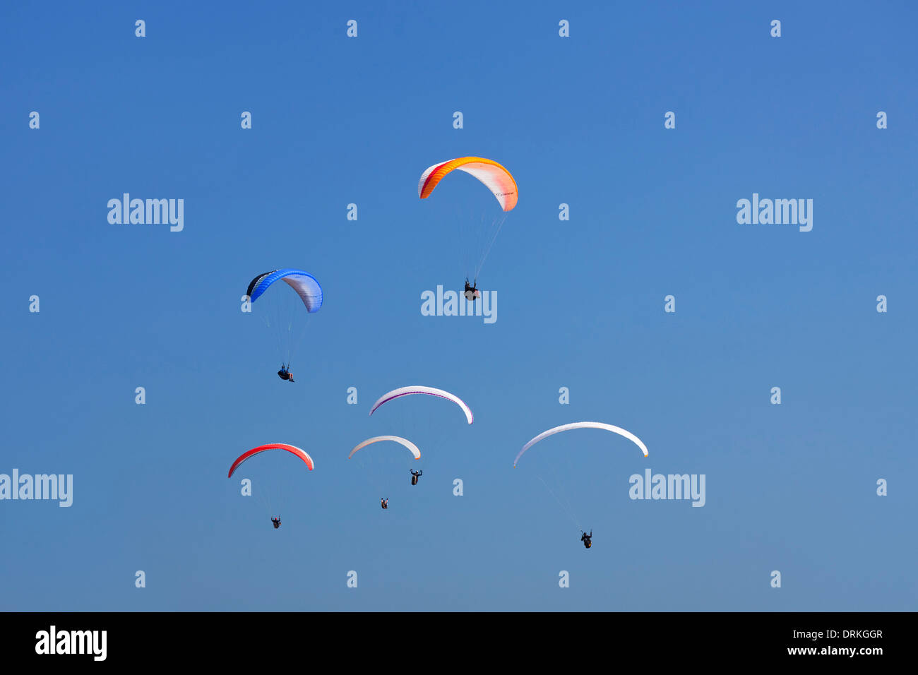 Group of paragliders in flight with colourful wings / canopies against ...