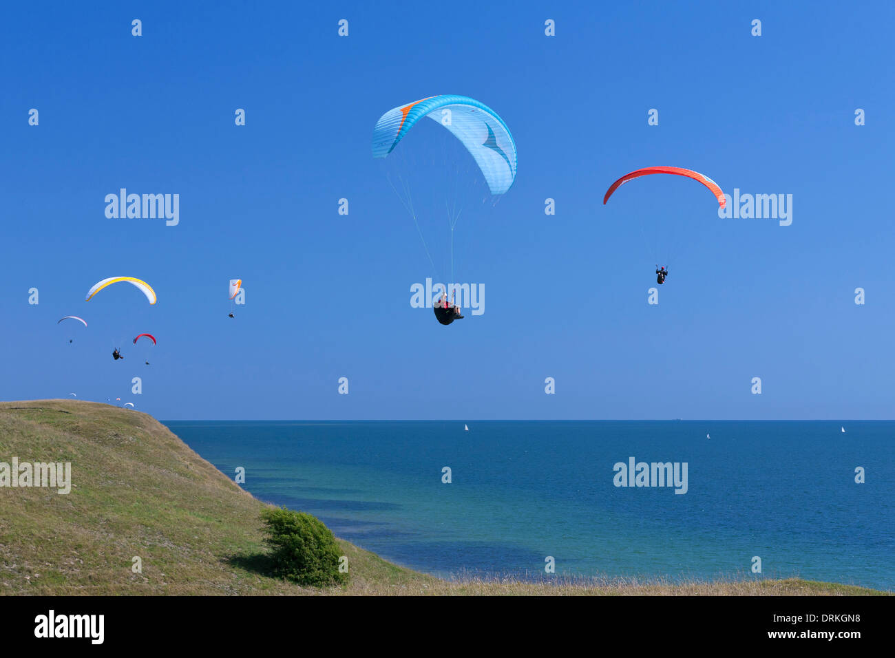 Group of paragliders in flight with colourful wings / canopies flying ...