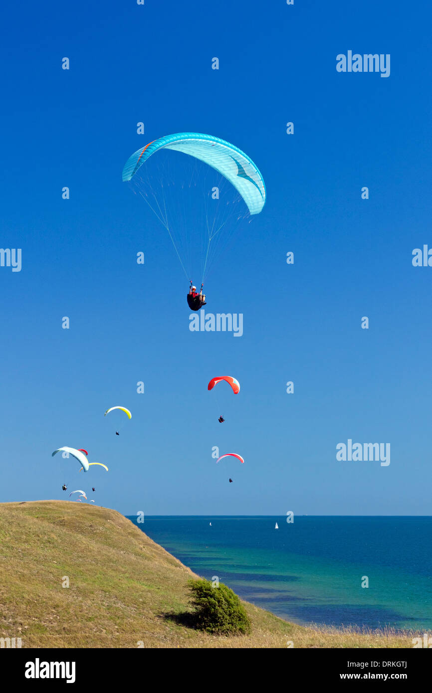 Group of paragliders in flight with colourful wings / canopies flying ...