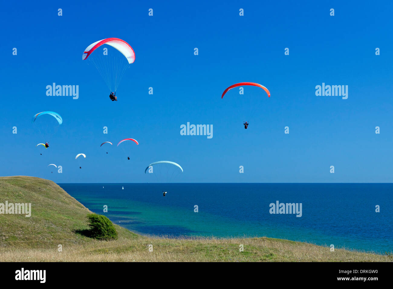 Group of paragliders in flight with colourful wings / canopies flying ...