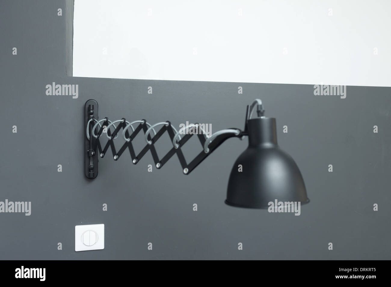 Black adjustable lamp mounted on grey wall Stock Photo - Alamy