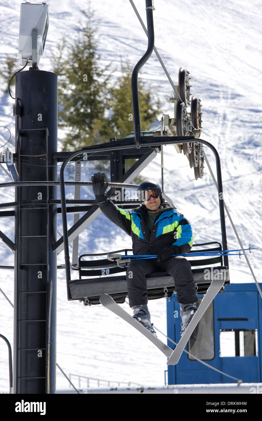 Man skier waving from chair lift Stock Photo - Alamy