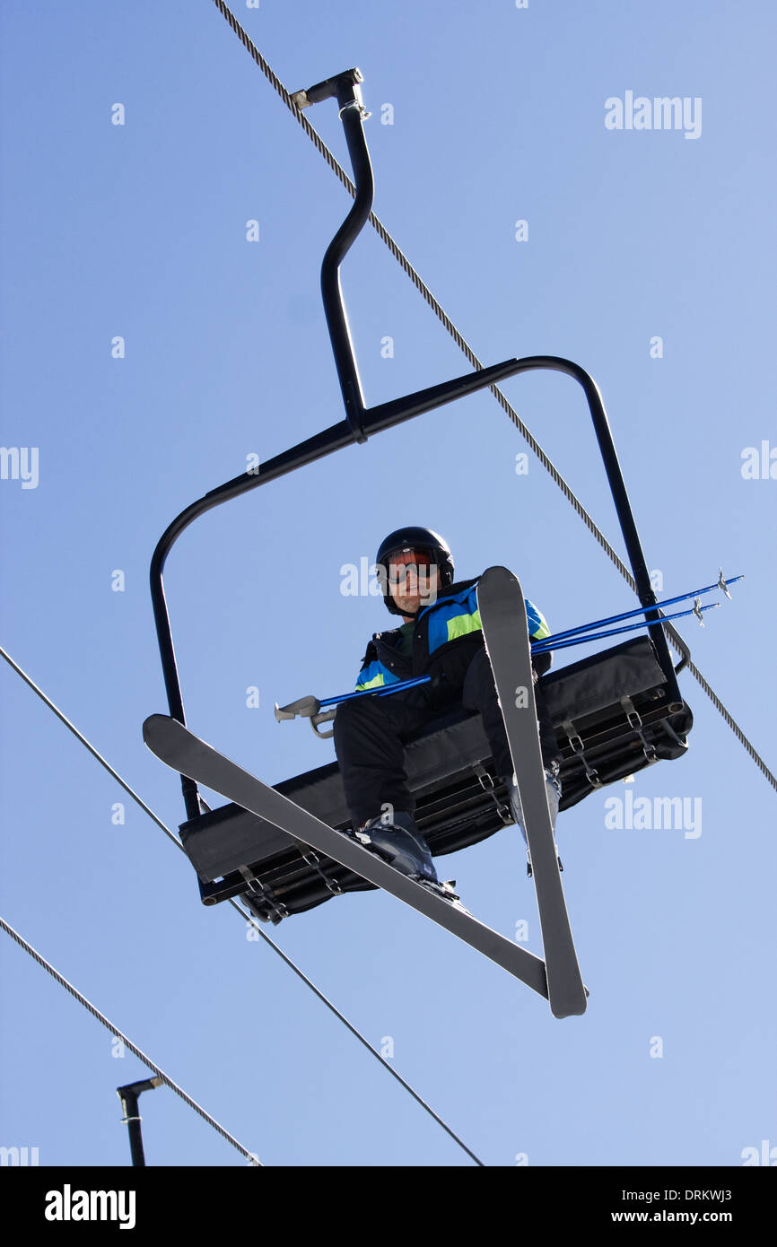 Man skier on chair lift going up the mountain Stock Photo - Alamy