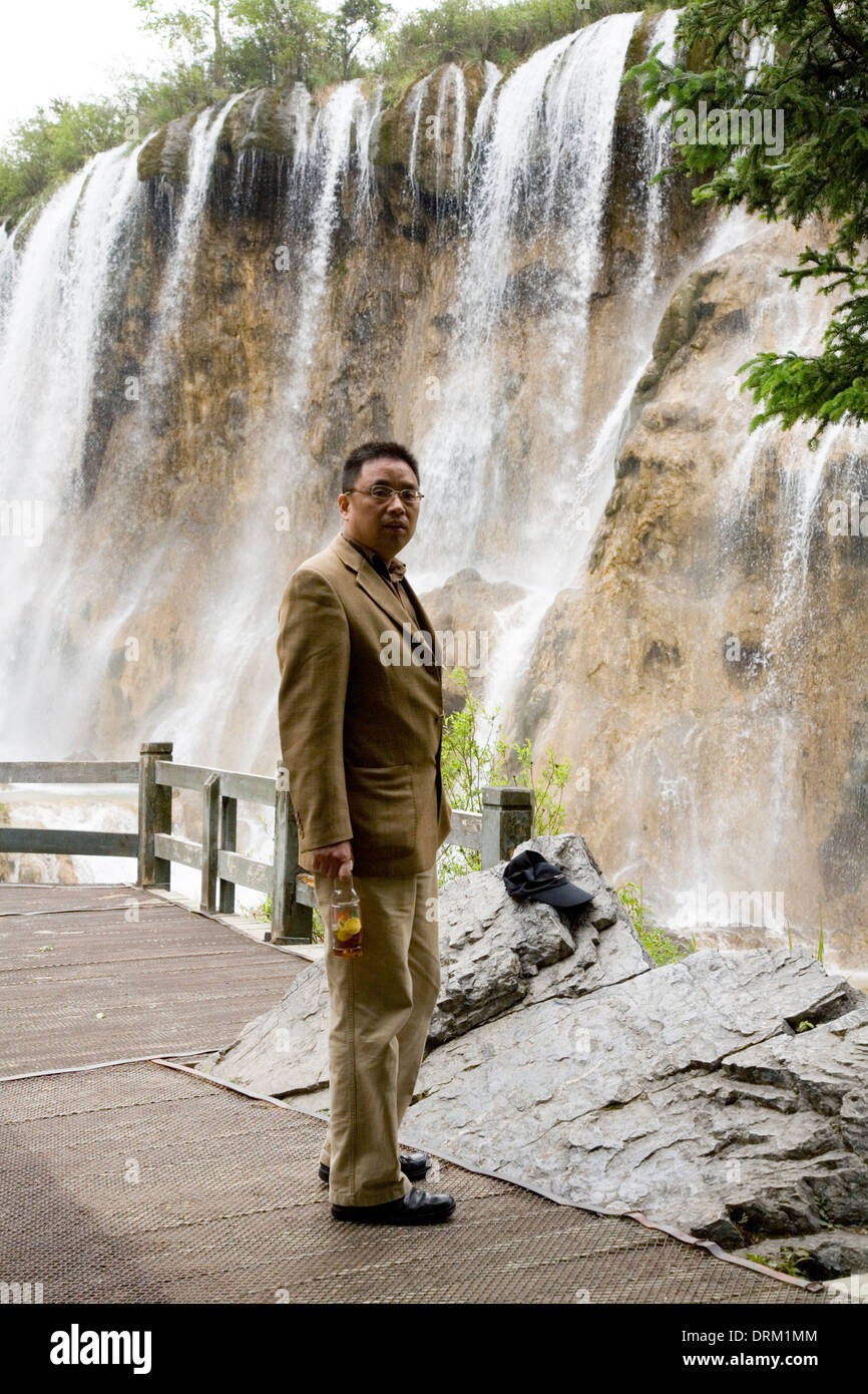 Chinese male tourist in front of waterfall / water falls / water fall ...