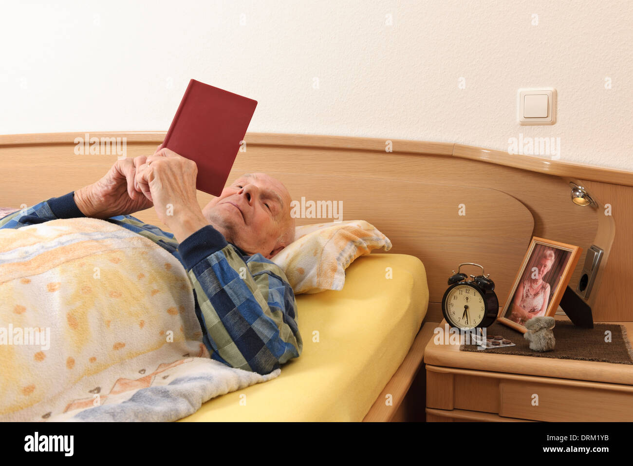 Old man reading in bed Stock Photo - Alamy