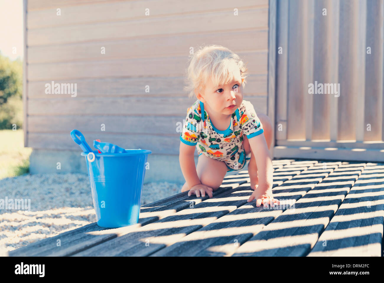 Little boy crouching on terrace Stock Photo - Alamy
