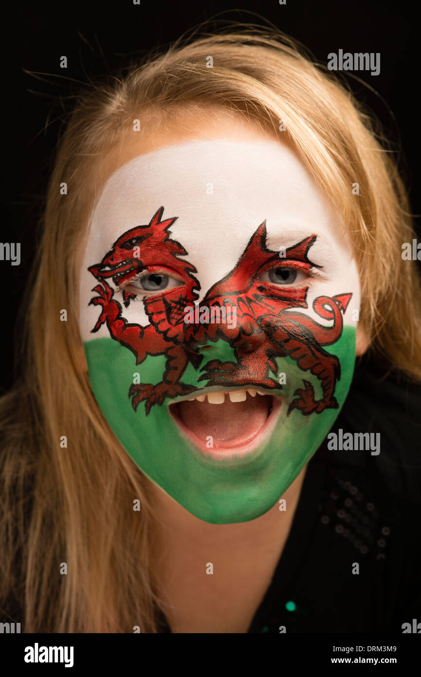 A happy smiling young girl child with the Welsh national banner red ...