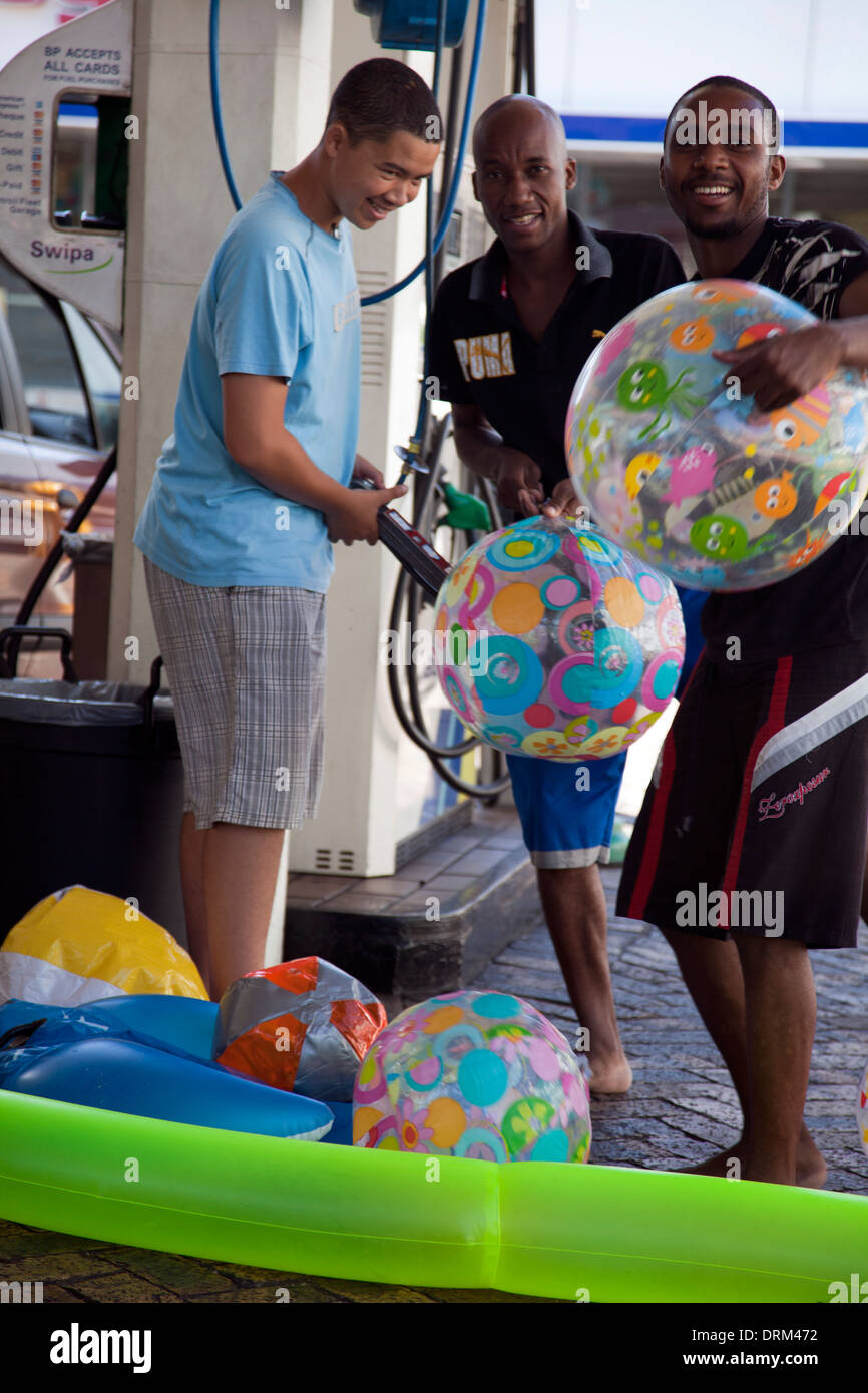 Group of Black Youths filling Inflatables with Air at garage in cape ...